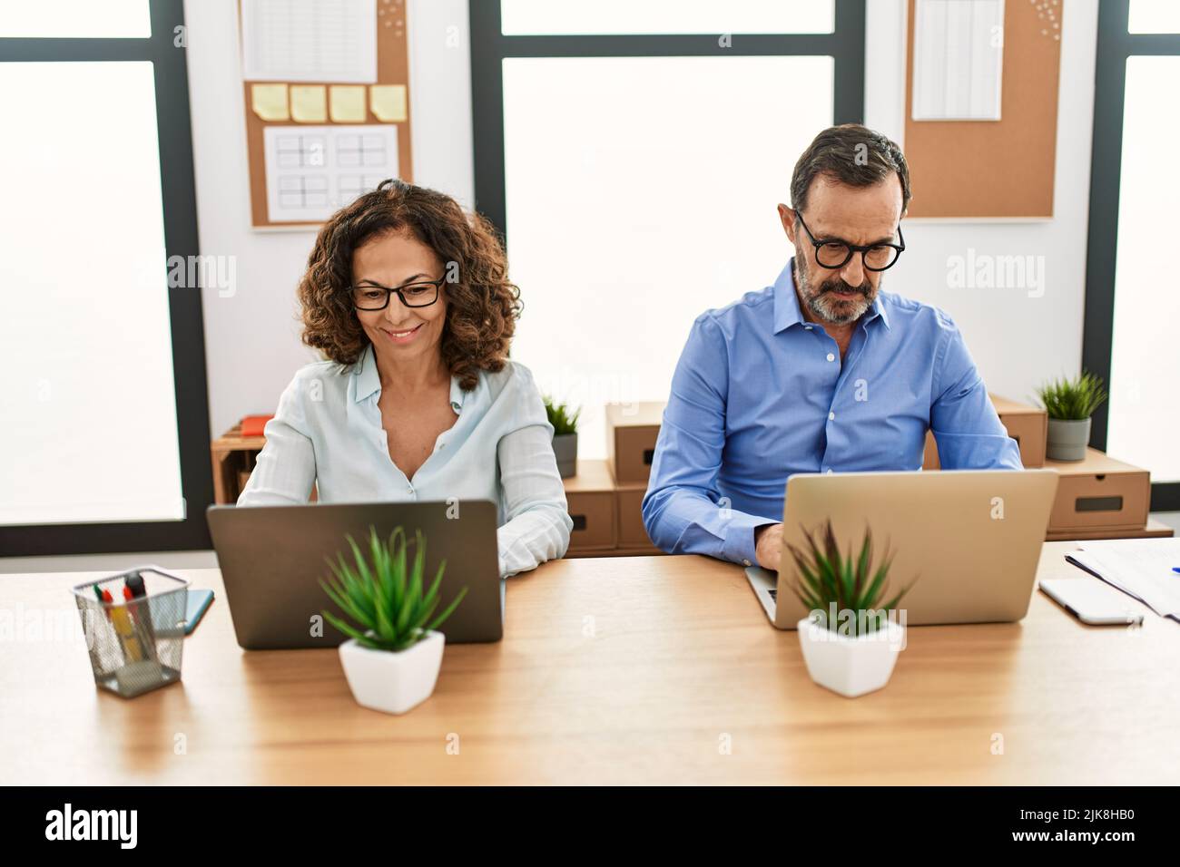 Two middle age business workers concentrated working at the office ...