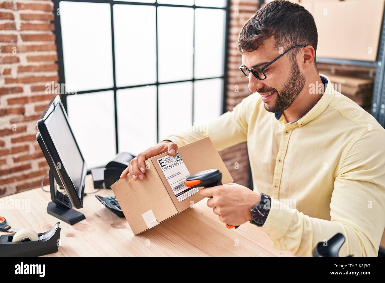 Young hispanic man ecommerce business worker scanning label using ...