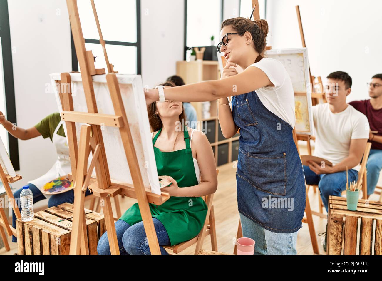 Paint teacher looking draw of student at art studio Stock Photo - Alamy