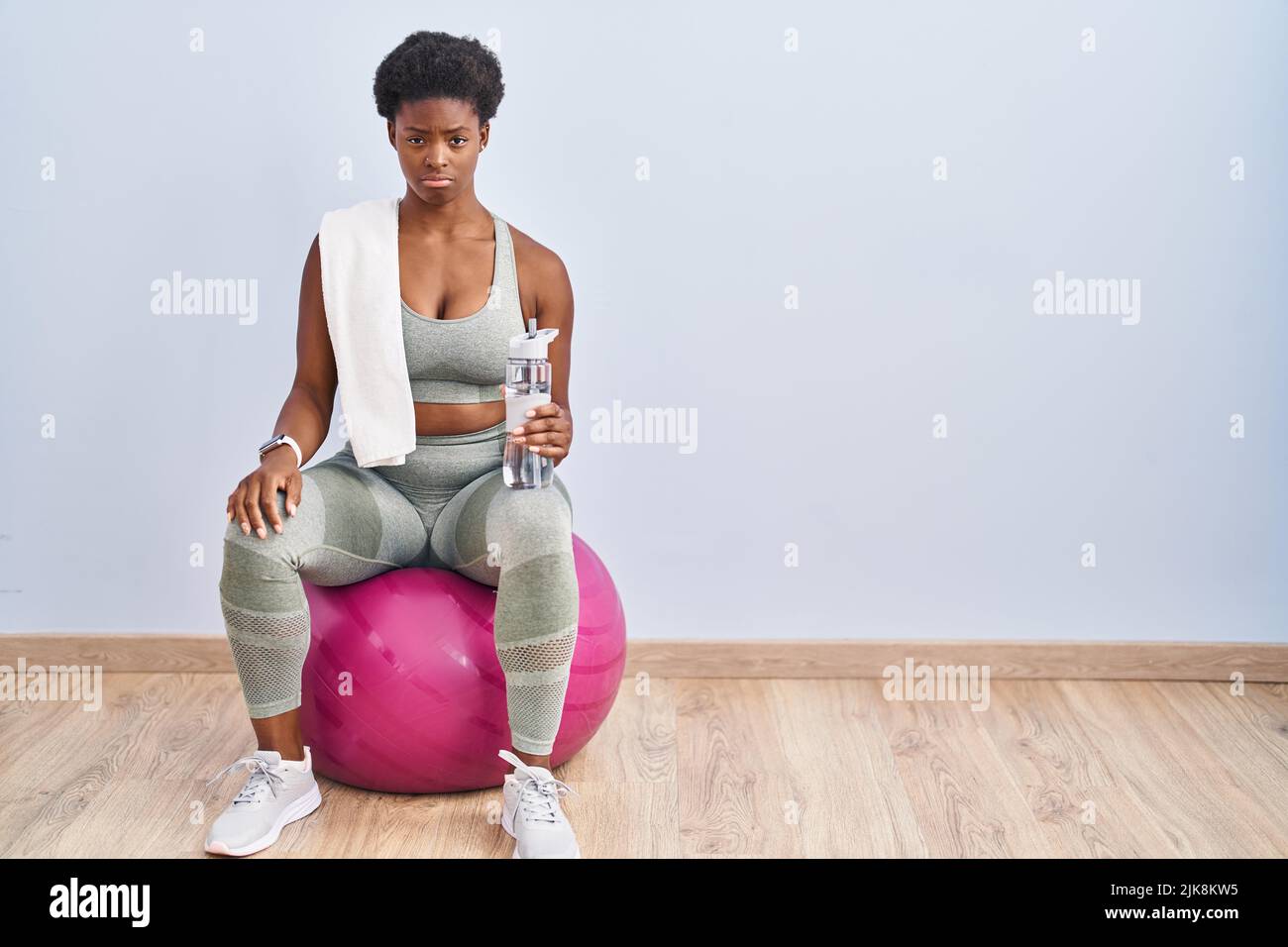 African american woman wearing sportswear sitting on pilates ball ...