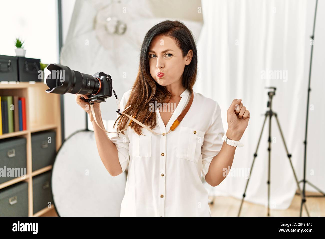 Beautiful caucasian woman working as photographer at photography studio ...