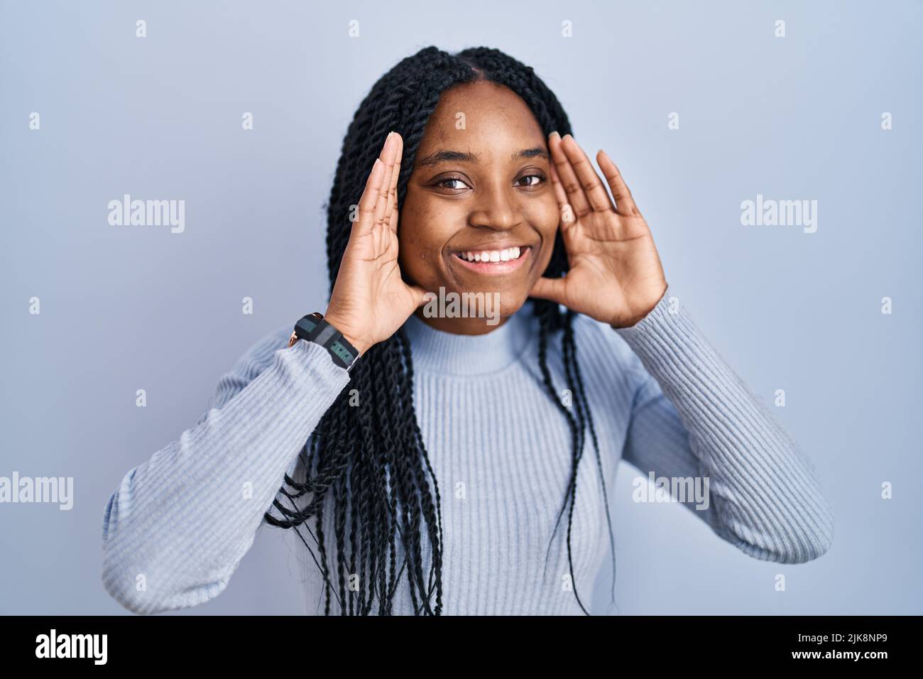 African american woman standing over blue background smiling cheerful ...