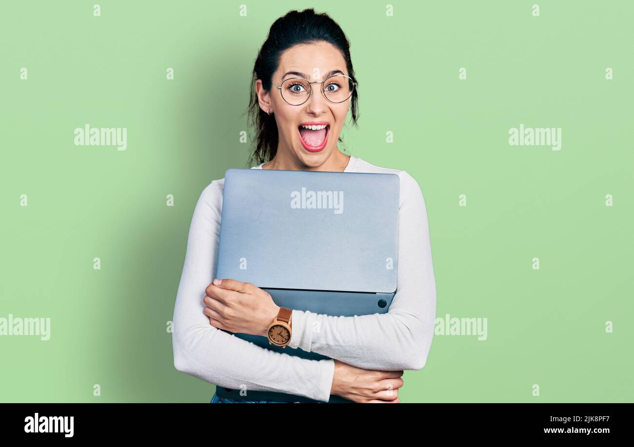 Young hispanic woman working using computer laptop celebrating crazy ...