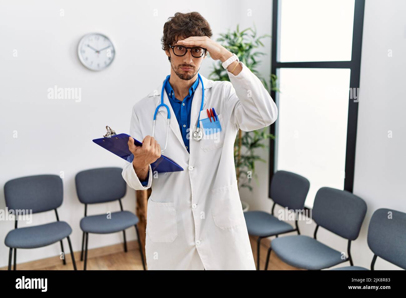 Young hispanic doctor man at waiting room worried and stressed about a ...