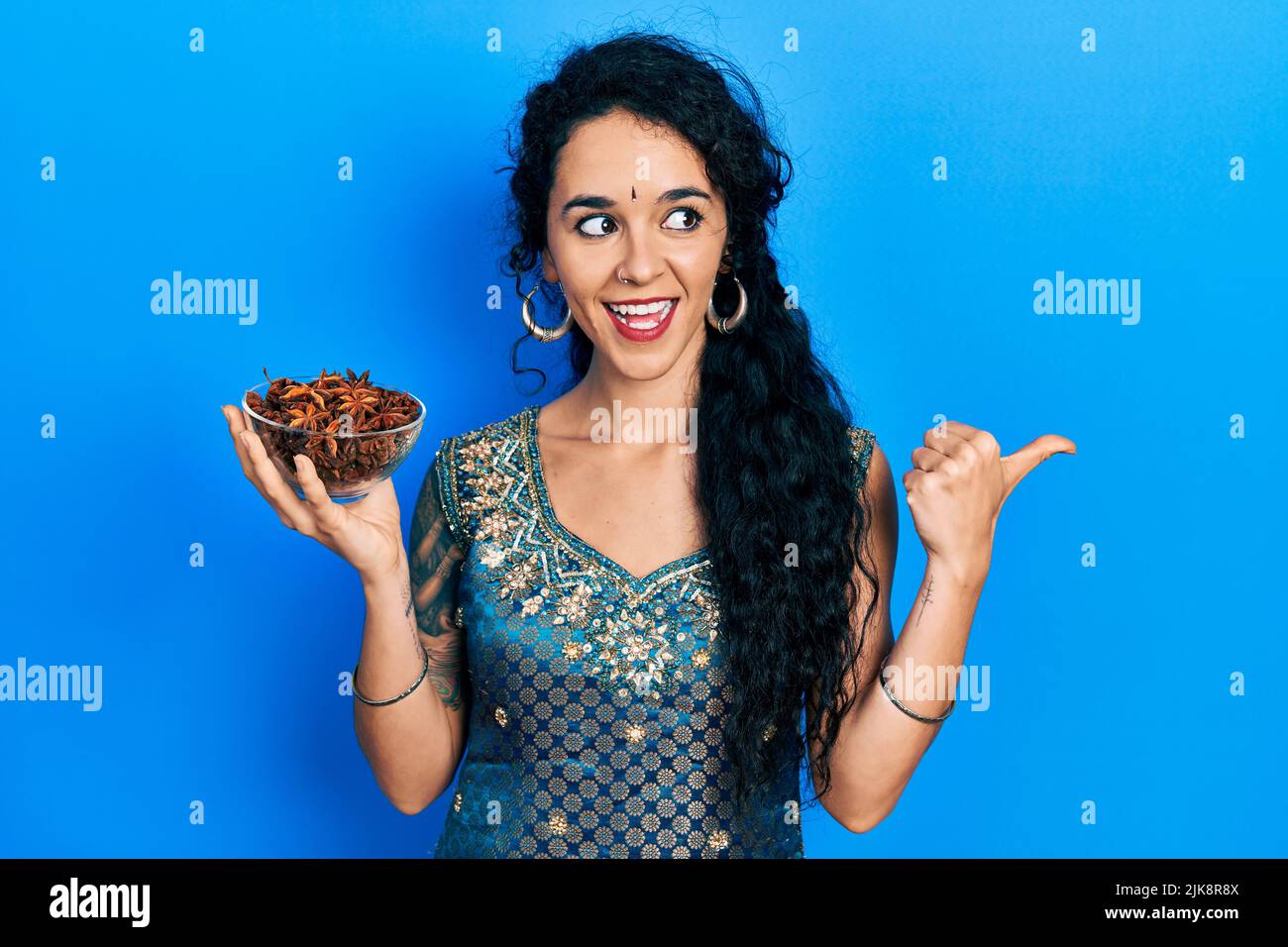 Young woman wearing bindi and traditional kurta dress holding bowl of ...