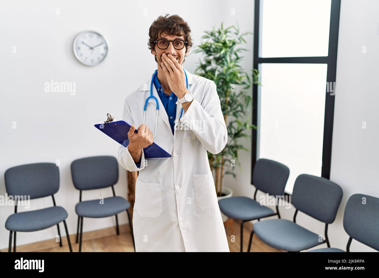 Young hispanic doctor man at waiting room laughing and embarrassed ...