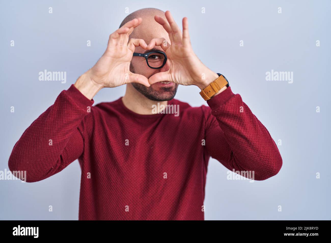 Young bald man with beard standing over white background wearing ...