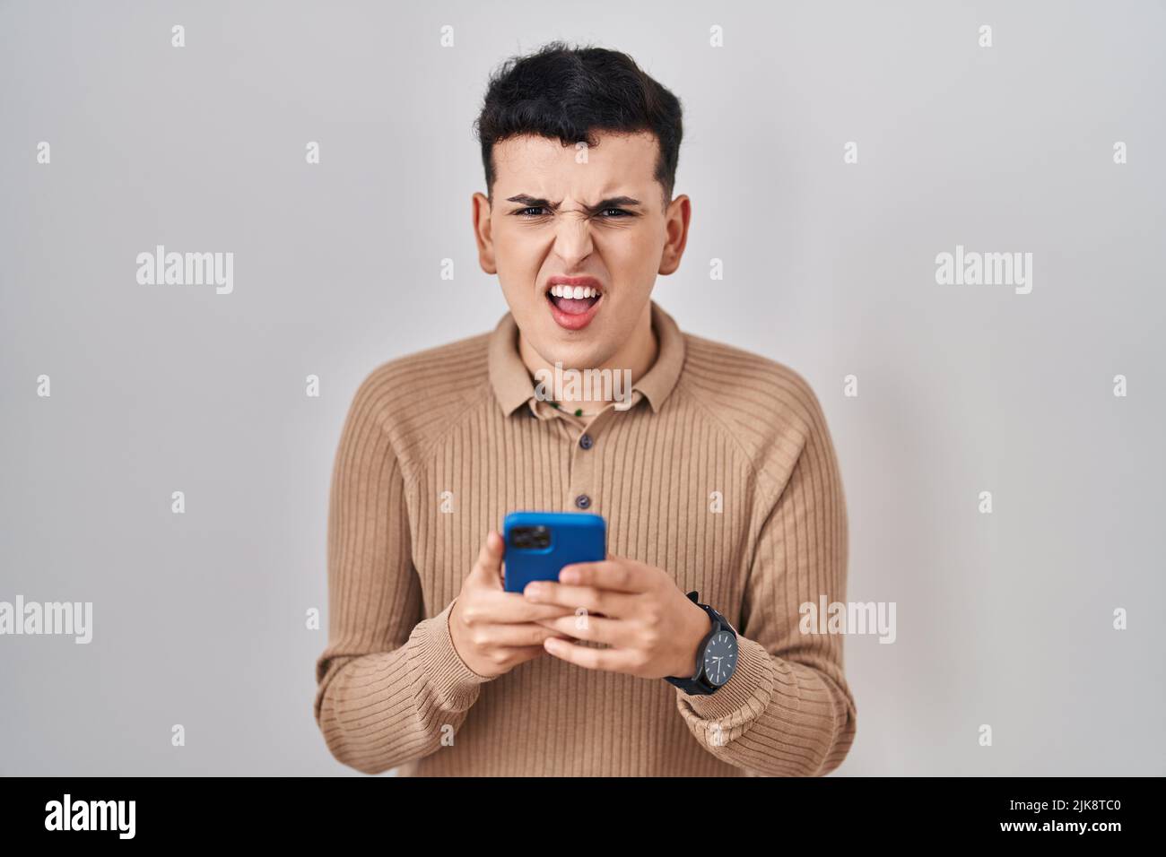 Non binary person using smartphone typing message angry and mad ...
