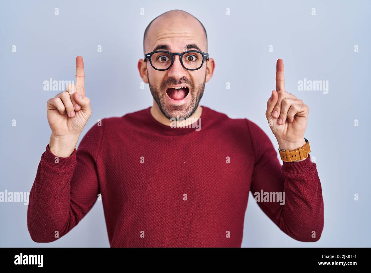 Young bald man with beard standing over white background wearing ... Young bald man with beard standing over white background wearing ...