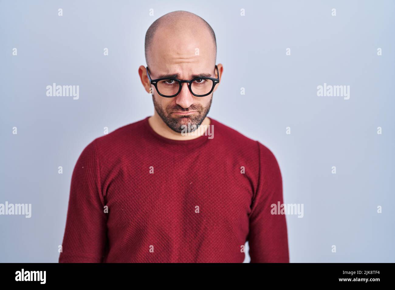 Young bald man with beard standing over white background wearing ...