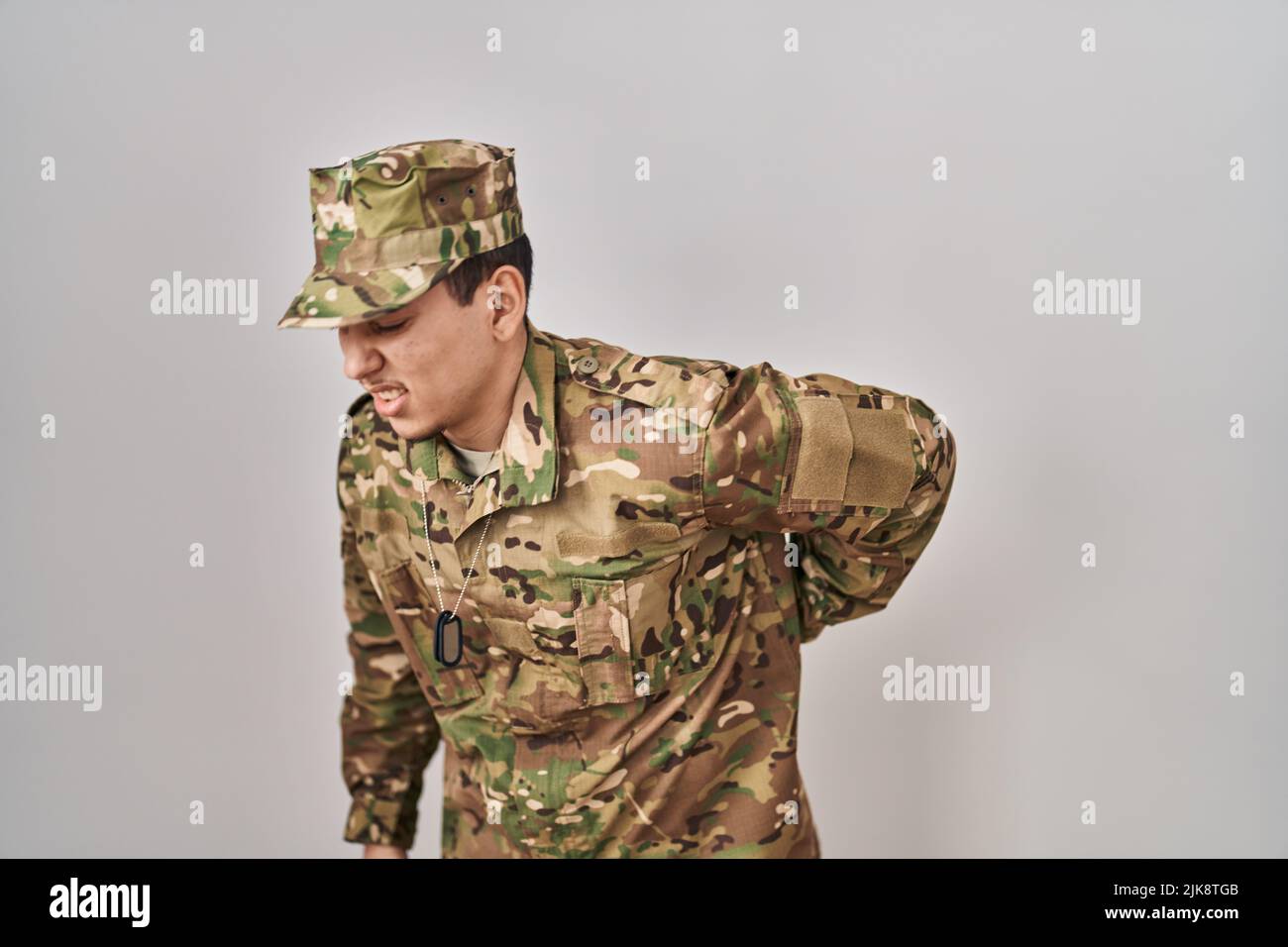 Young arab man wearing camouflage army uniform suffering of backache ...