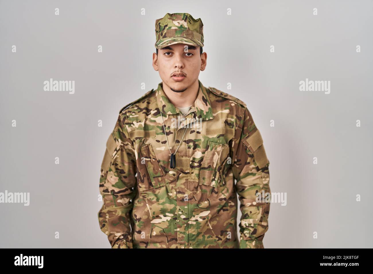 Young arab man wearing camouflage army uniform looking sleepy and tired ...