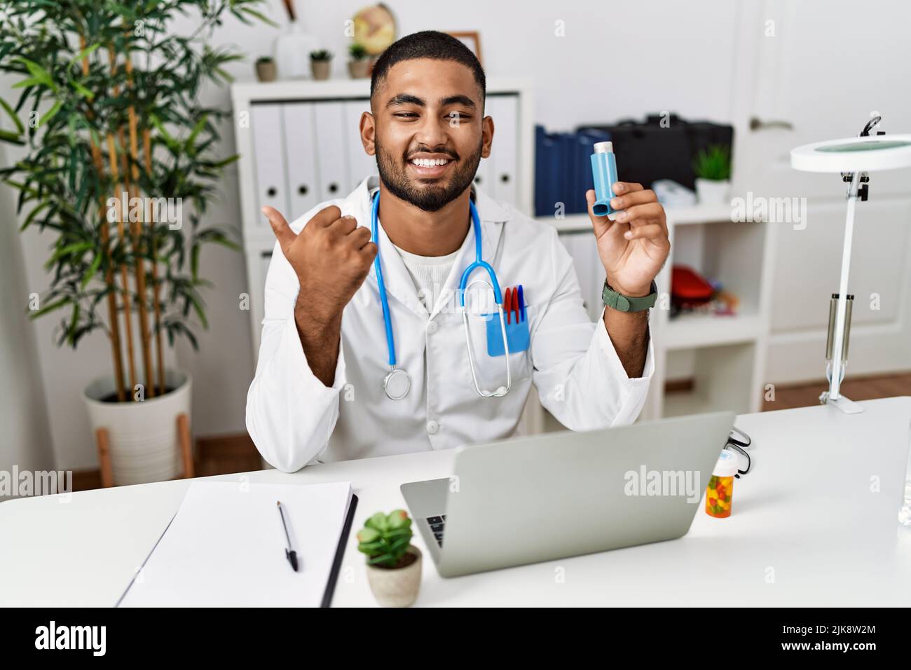 Young indian doctor holding medical asthma inhaler at the clinic ...