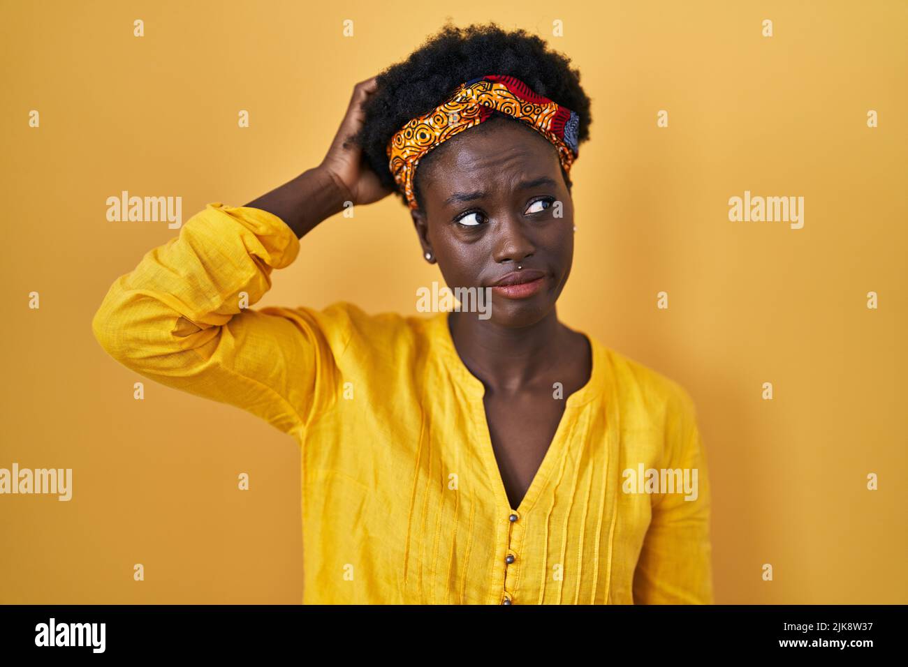 African young woman wearing african turban confuse and wonder about ...