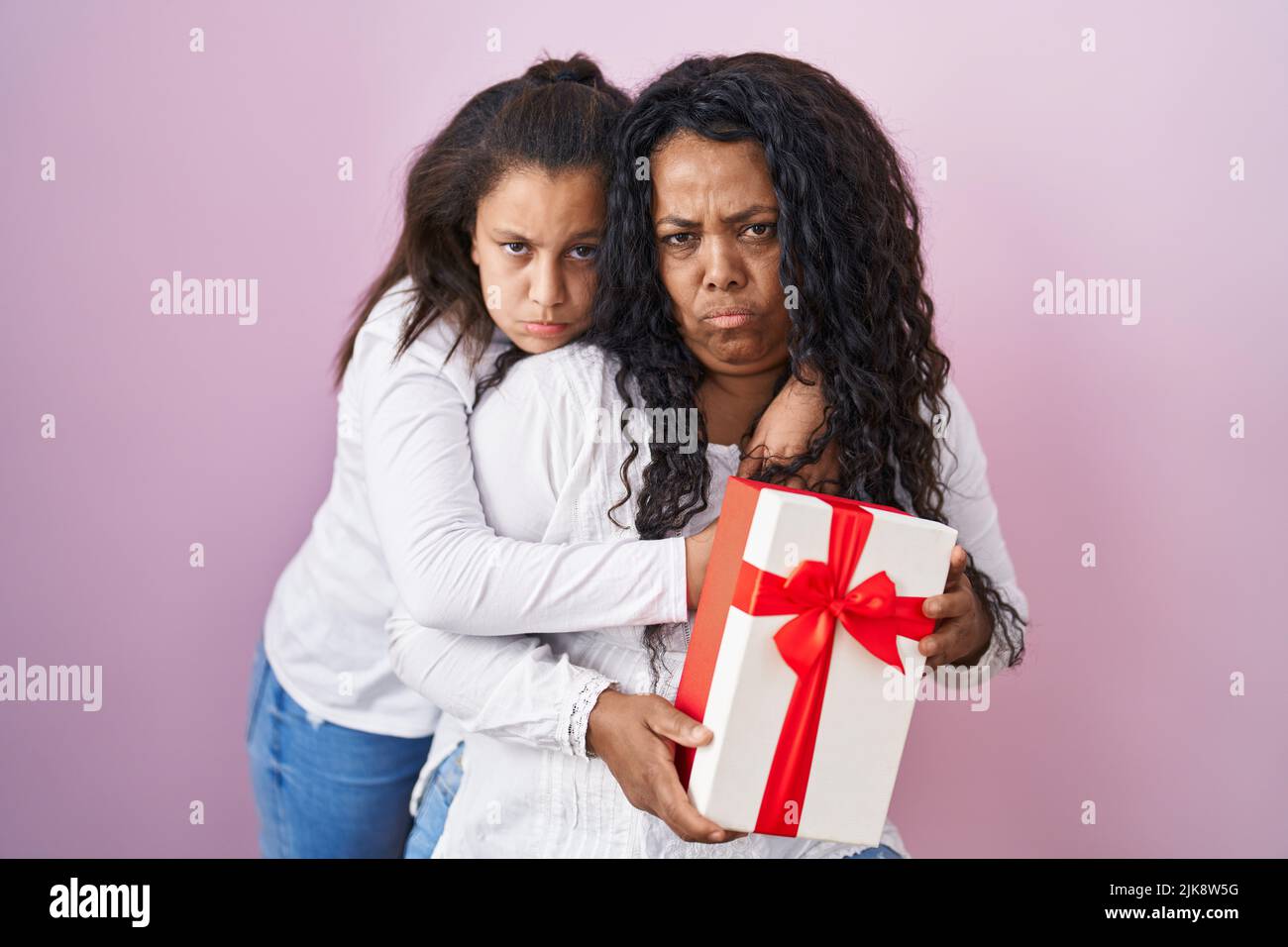 Mother and young daughter holding with presents depressed and worry for ...