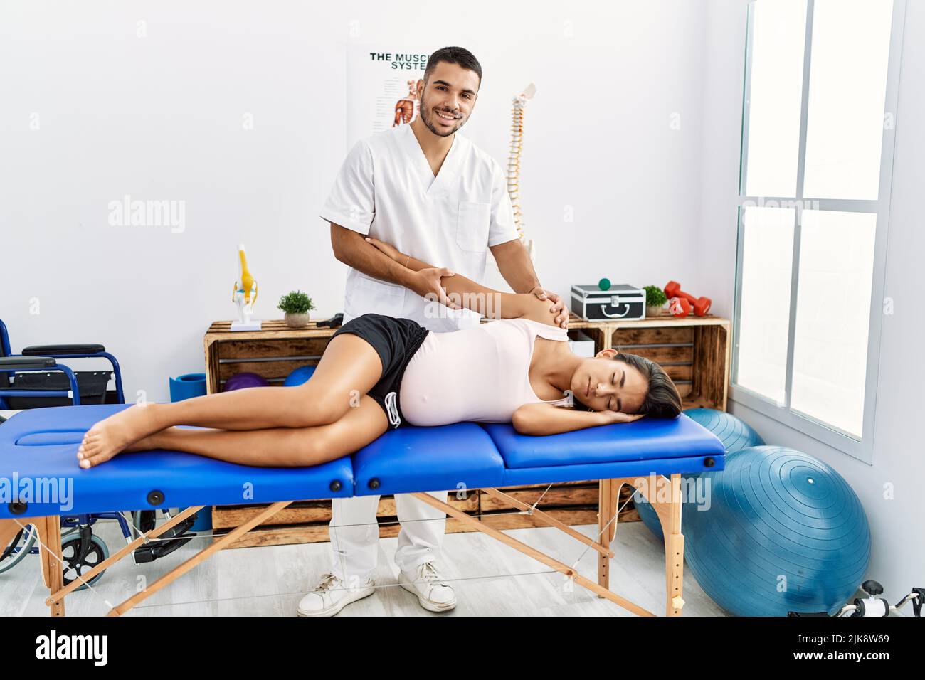 Latin man and woman wearing physiotherapist uniform having pregnancy ...