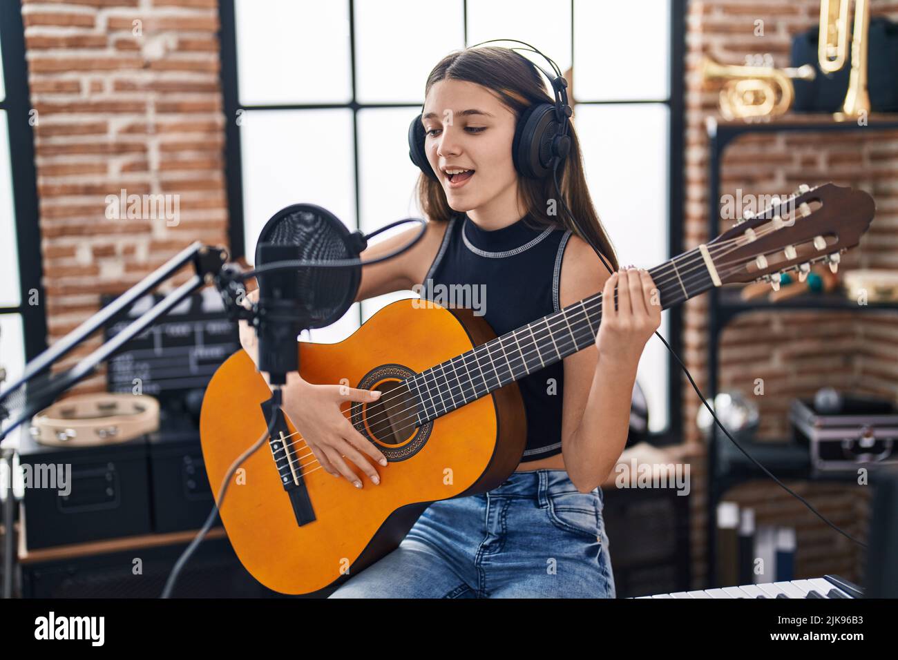 Adorable girl musician singing song playing classical guitar at music ...