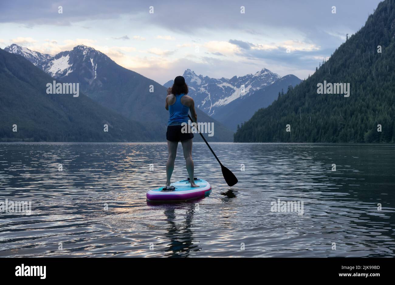 Adventurous Woman Paddle Boarding in a Lake around Canadian Mountain ...