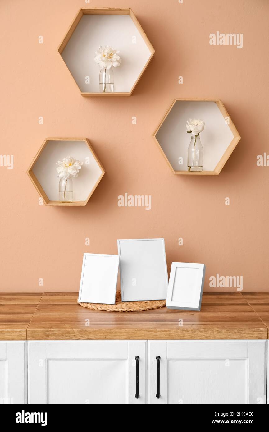 Blank photo frames on kitchen counter and shelves with beautiful peony ...