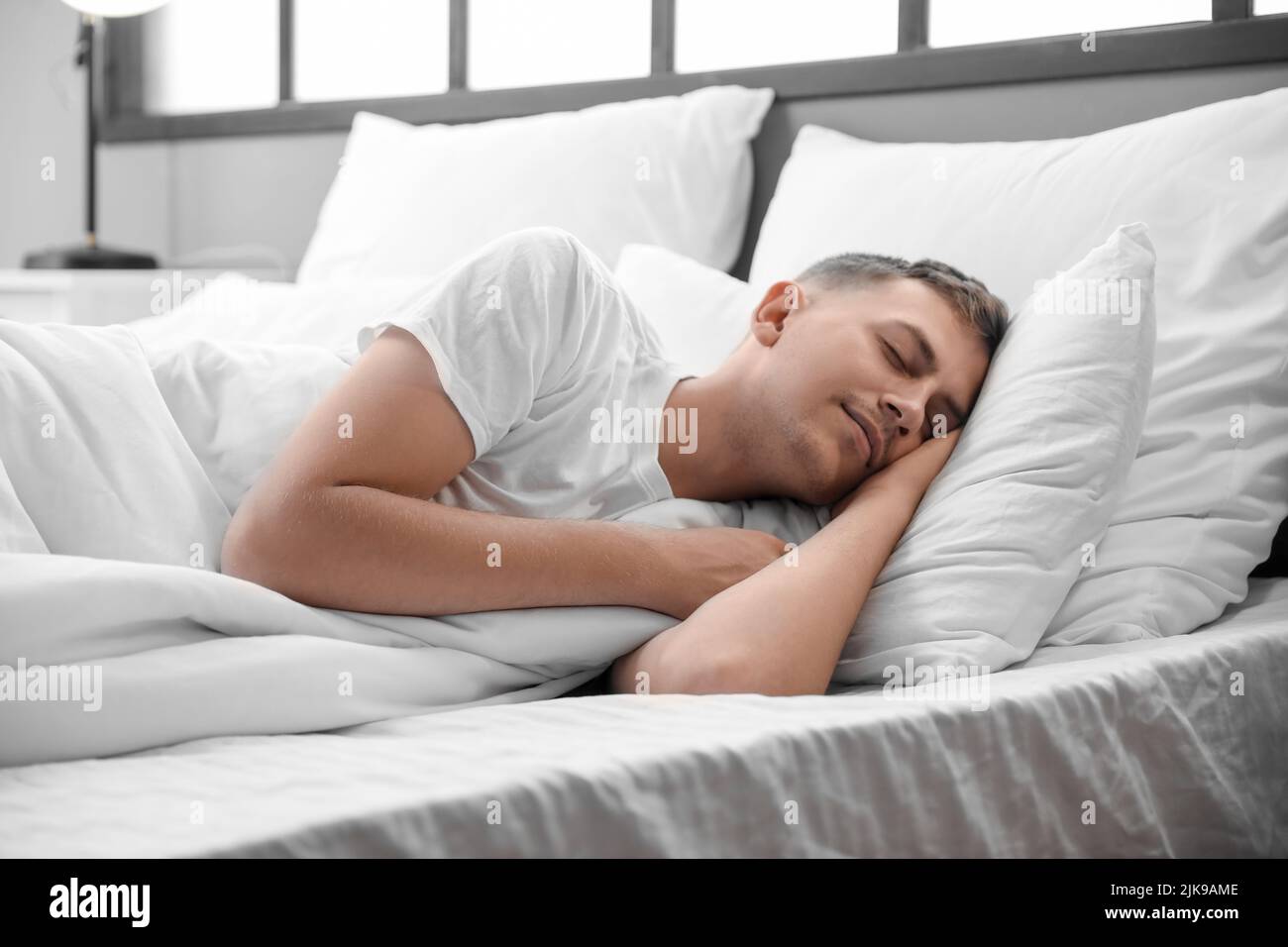 Handsome young man sleeping in bed at home Stock Photo - Alamy