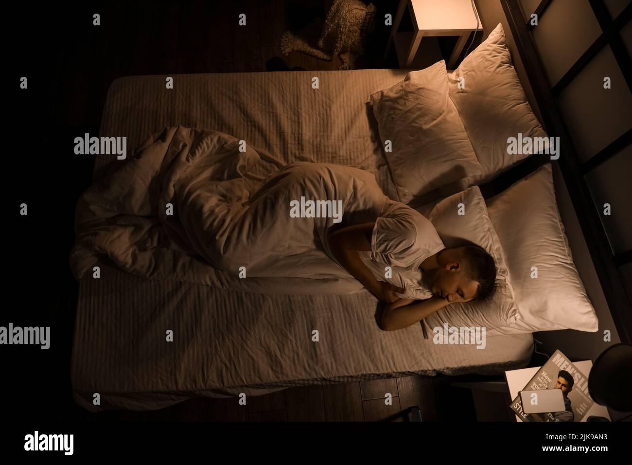 Handsome young man sleeping in bedroom at night Stock Photo - Alamy
