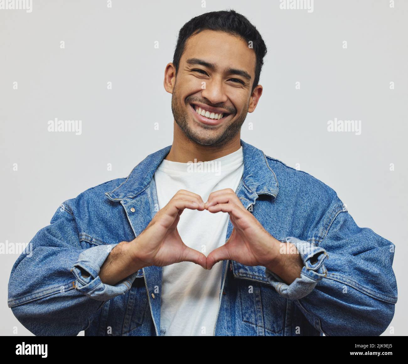 Much Love Cropped Portrait Of A Handsome Young Man Making A Heart