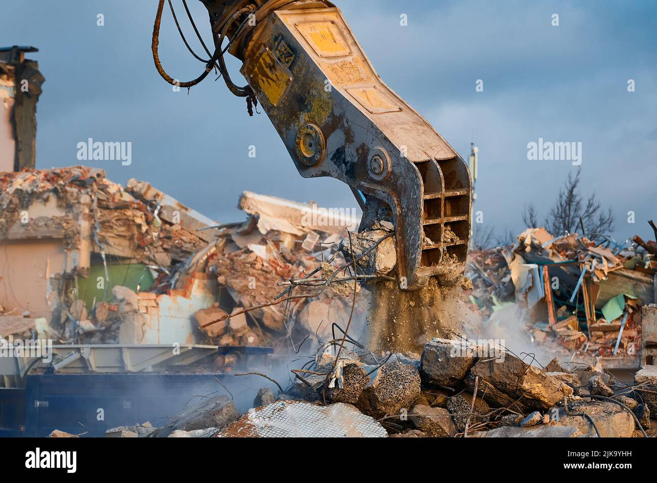 Crusher destroys reinforced concrete at demolition site Stock Photo - Alamy
