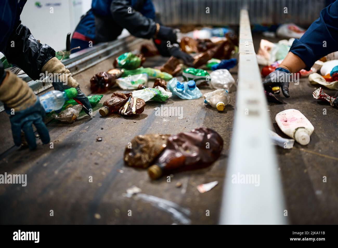 Worker sorts trash on conveyor belt at waste recycling plant Stock Photo - Alamy
