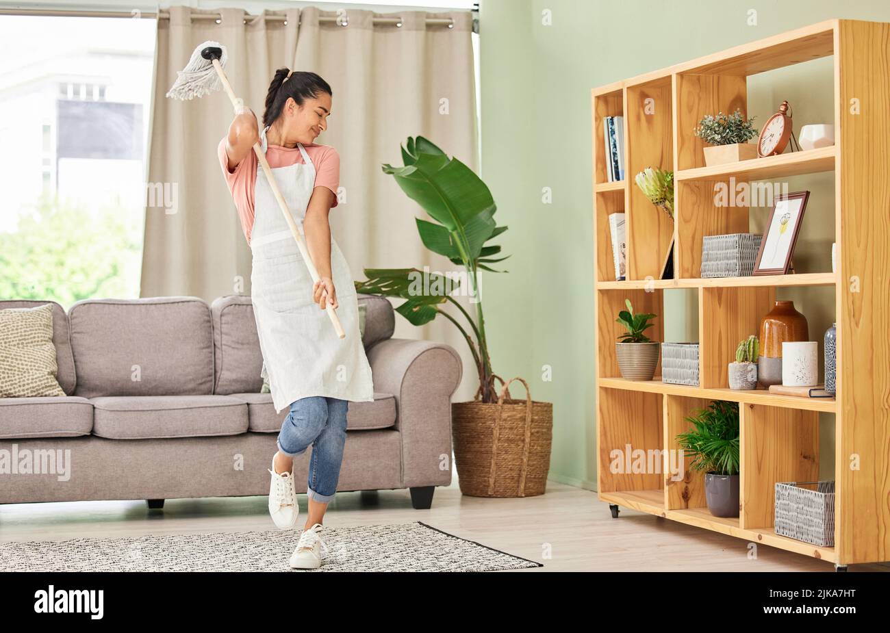 Some random fun while doing chores. a young woman dancing with a mop ...