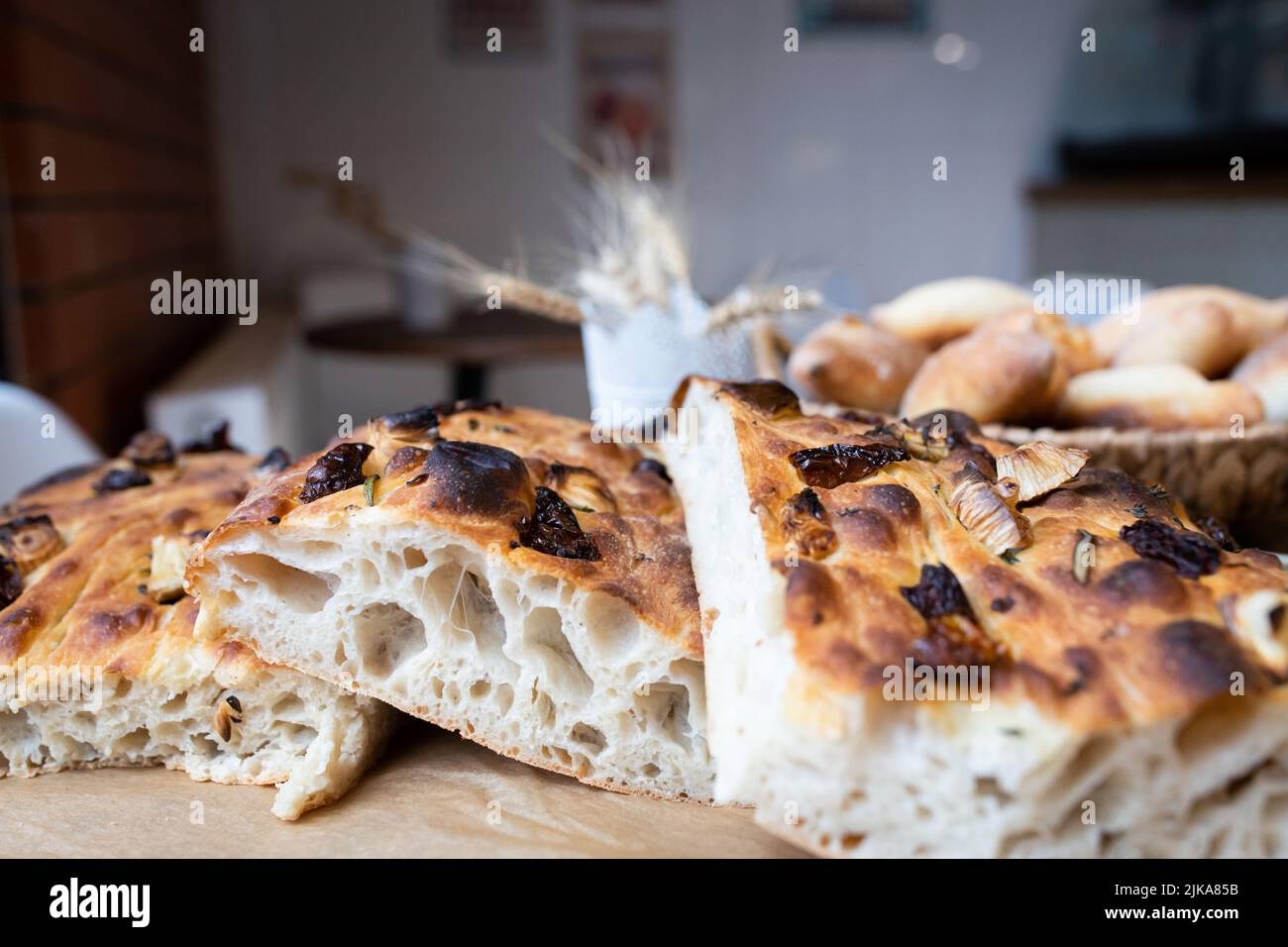Traditional Italian focaccia bread on a tray surrounded by other bread ...