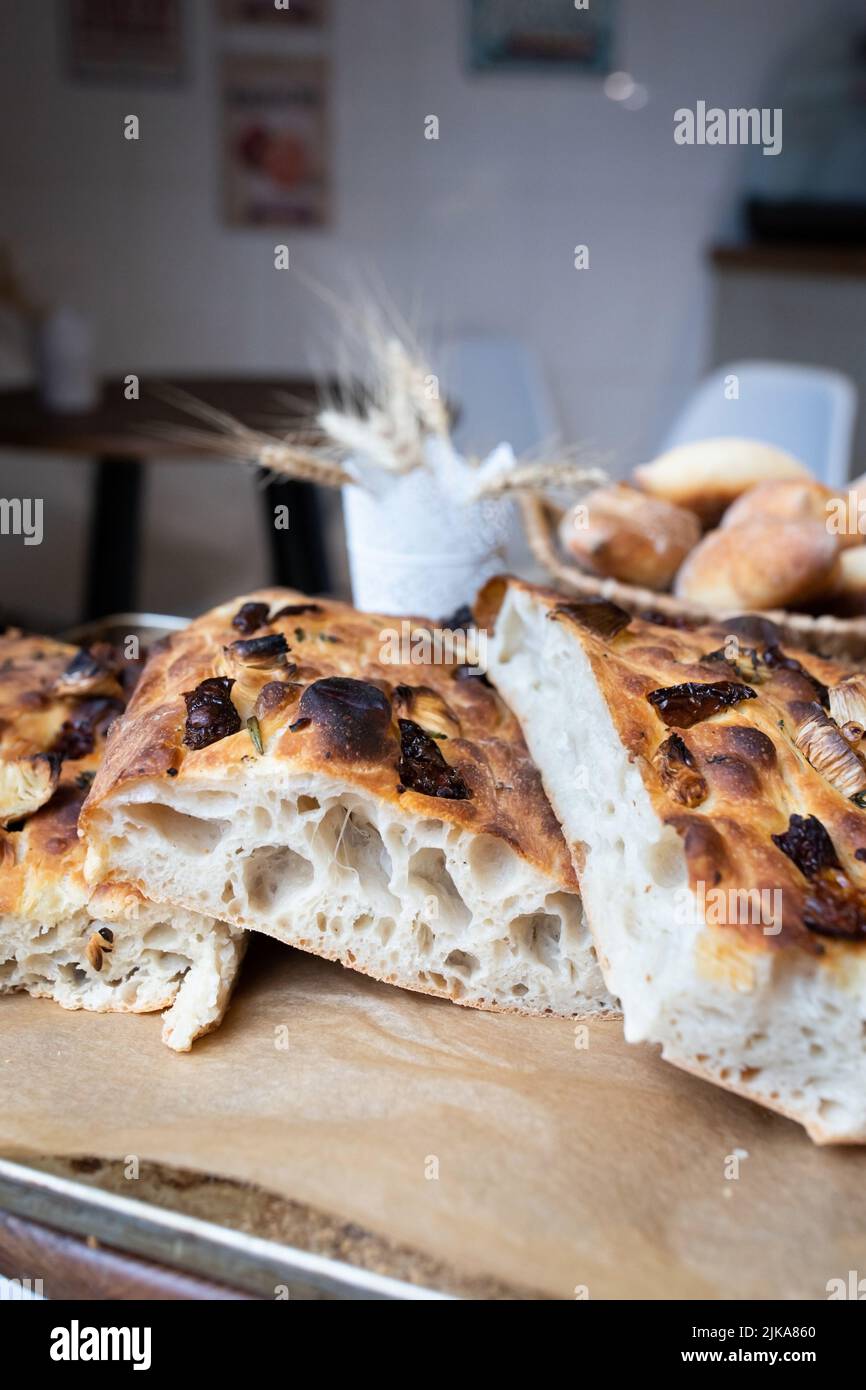 Traditional Italian focaccia bread on a tray surrounded by other bread ...