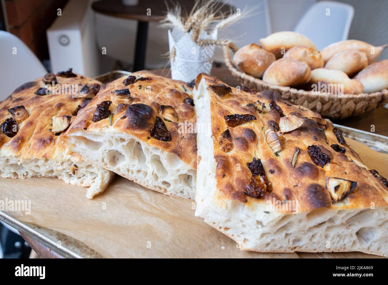 Traditional Italian focaccia bread on a tray surrounded by other bread ...