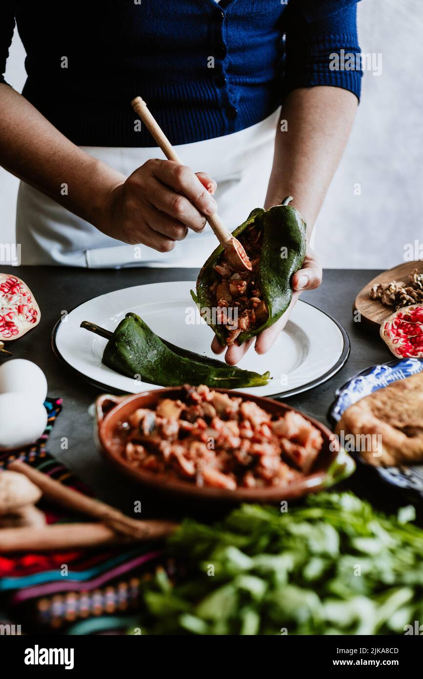 mexican woman cooking chiles en nogada recipe with Poblano chili and ...