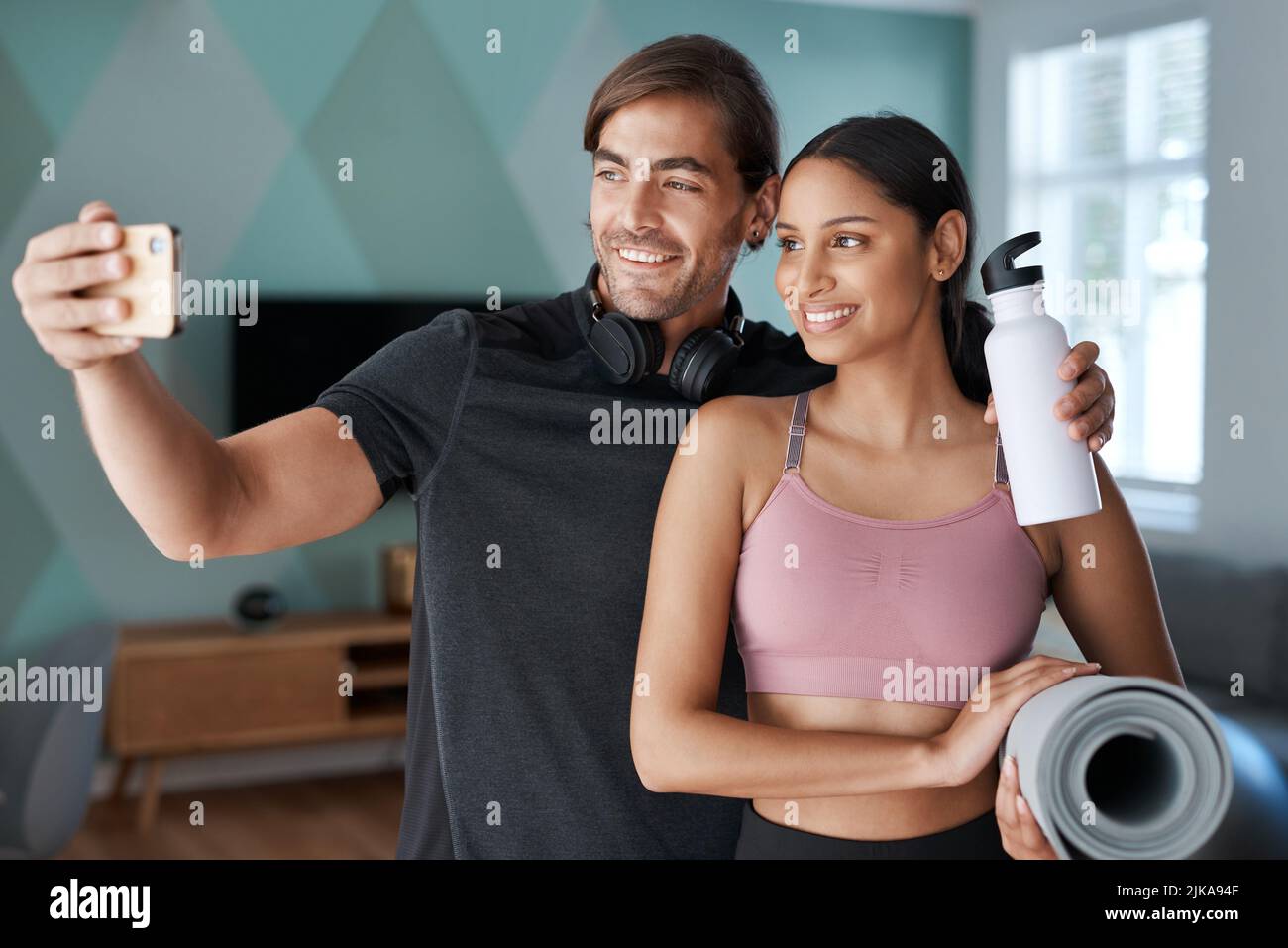 Pre-workout selfie. an athletic young couple taking selfies before starting their workout at ...