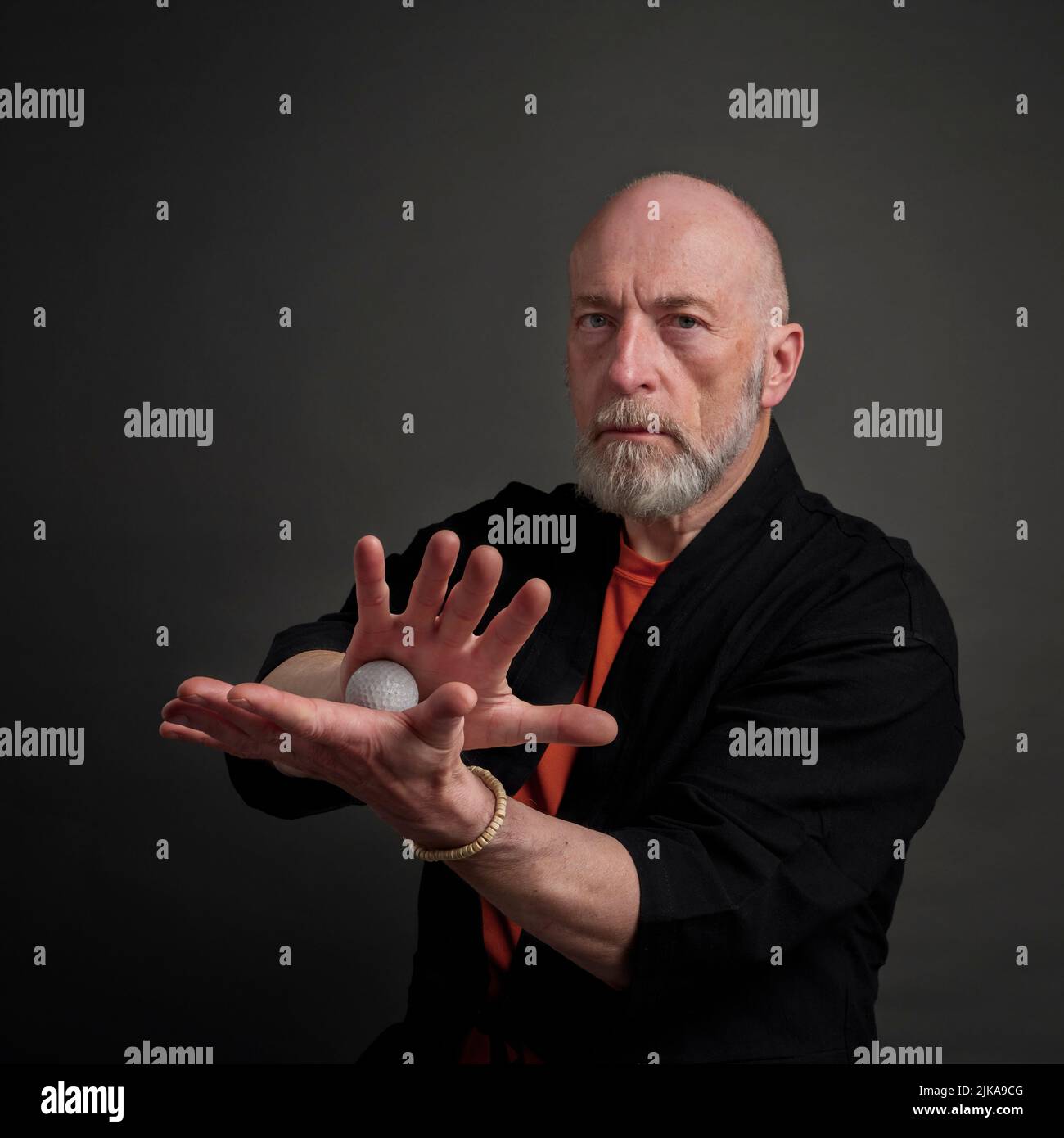 senior man is practicing reflexology therapy by rolling and pressing a ...