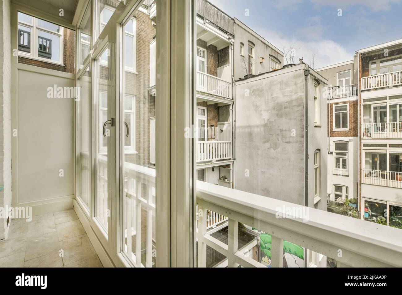 Front view of old brick buildings from small balcony with railings ...