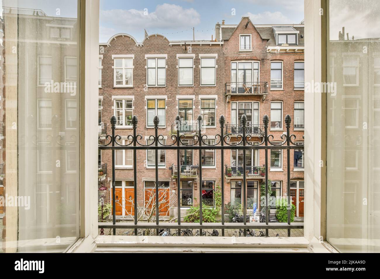 Front view of old brick buildings from small balcony with railings ...