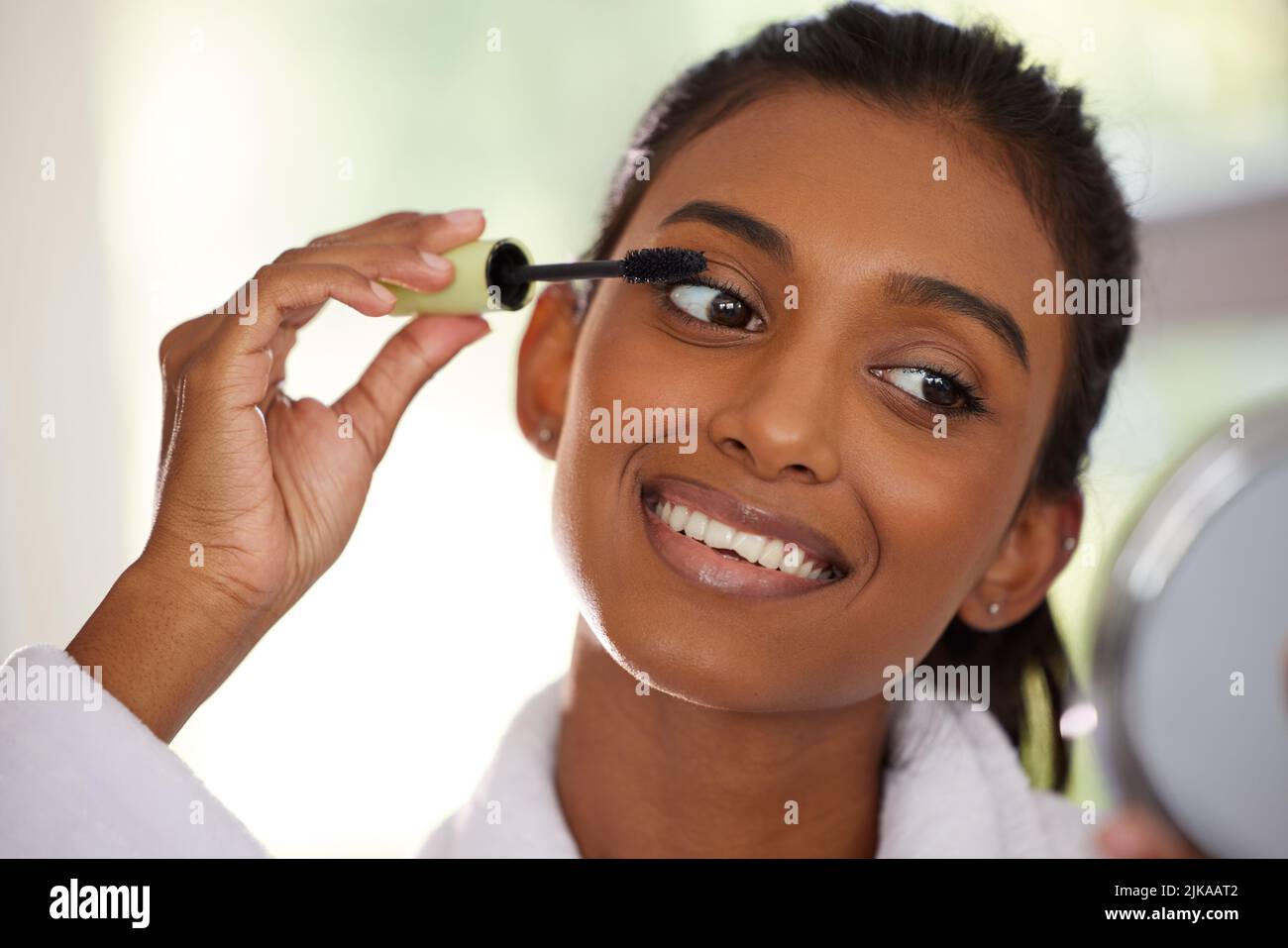 A little mascara makes a big difference. a beautiful young woman going ...