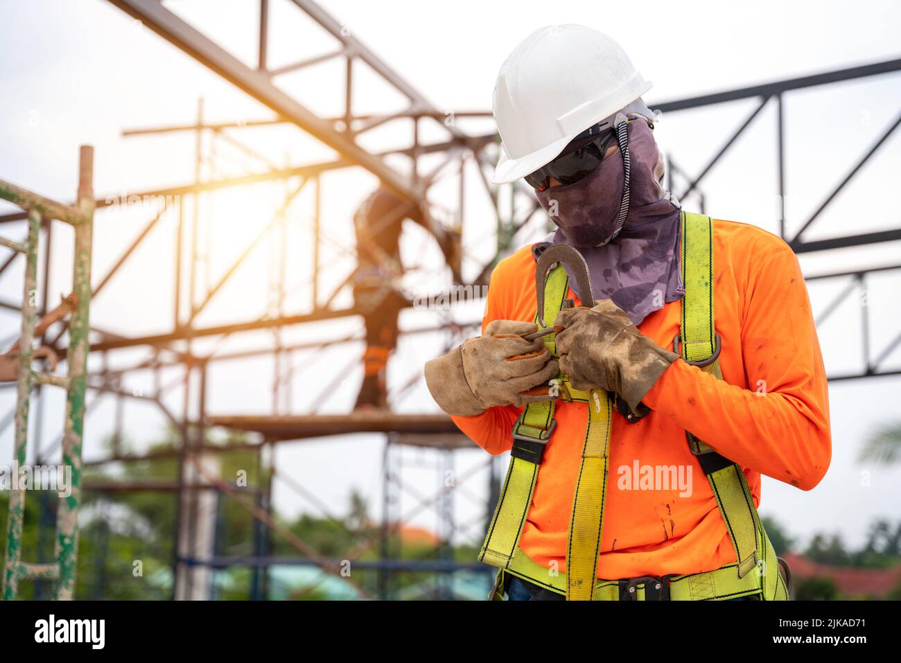 A Construction workers are installing safety equipment to prevent falls ...