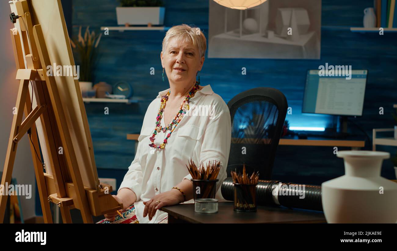 Portrait of old artist drawing masterpiece on canvas with creative ...