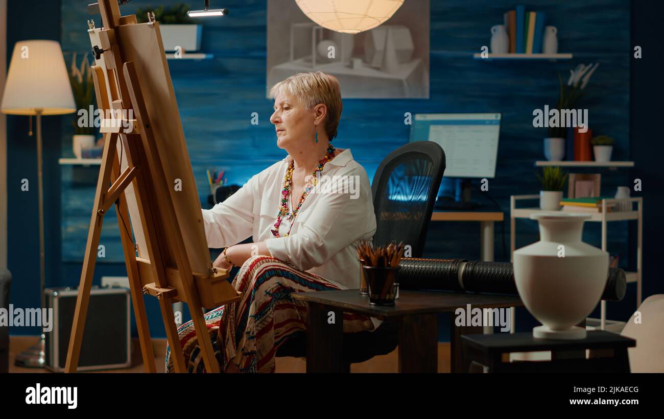 Senior artist creating authentic sketch with pencils on canvas, using ...