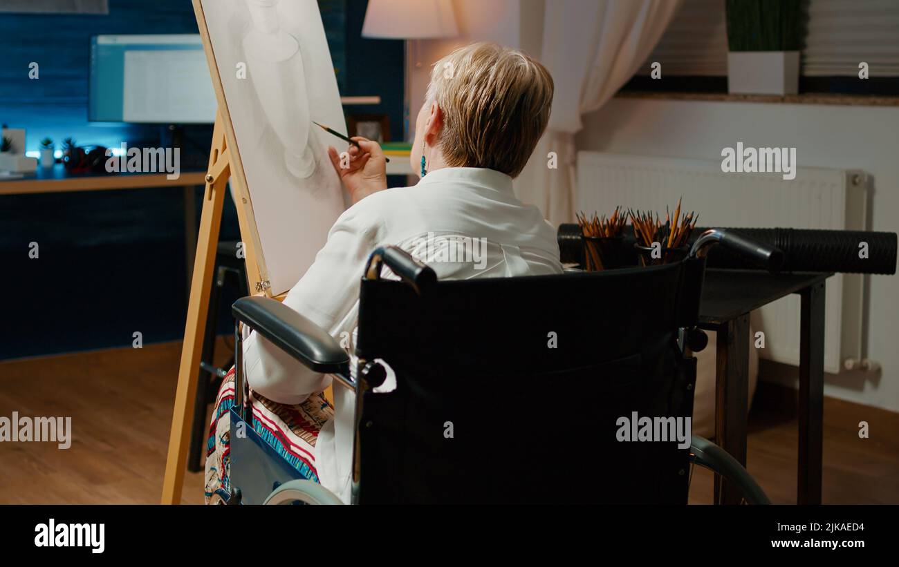 Wheelchair user drawing professional masterpiece for hobby, suffering ...
