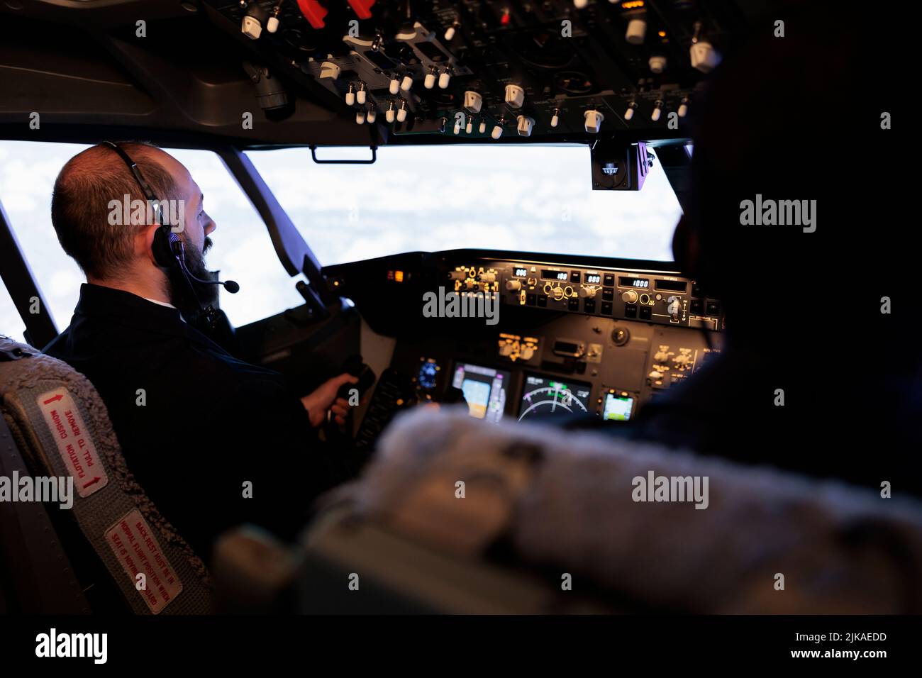 Male aviators flying airplane from cockpit with control panel and ...