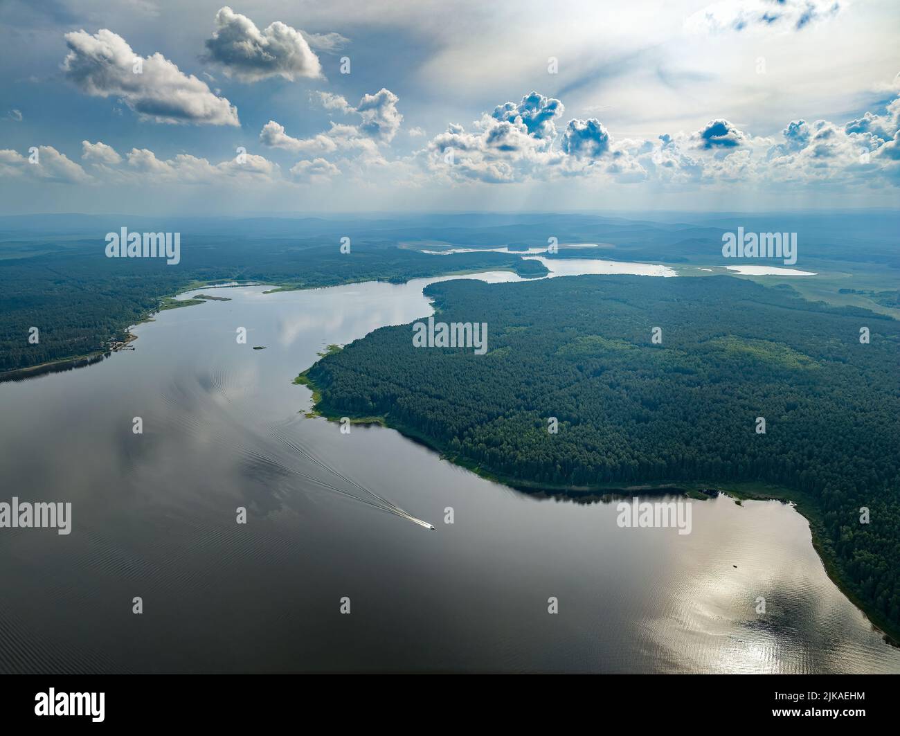 Big lake with green shores in bright sun light, aerial landscape ...