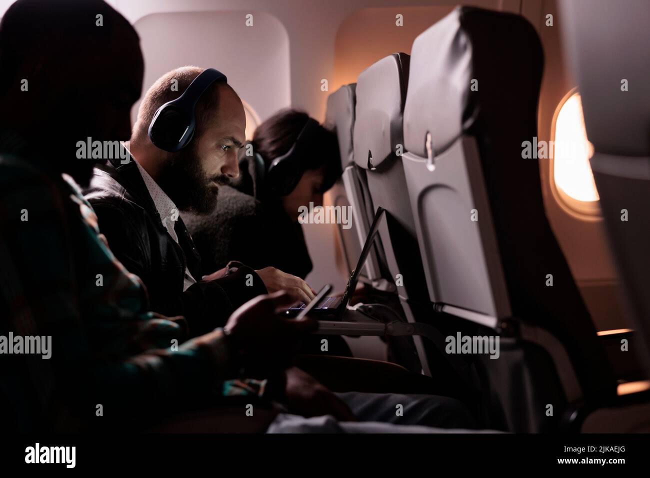 Group of passengers travelling on commercial flight by jet, being ...