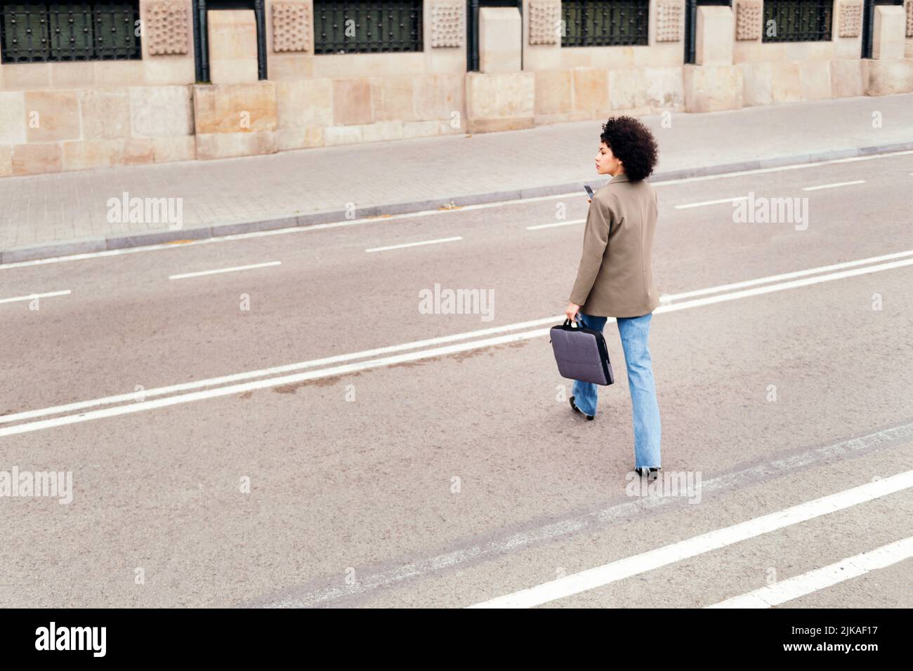 successful young woman walking across the street Stock Photo - Alamy