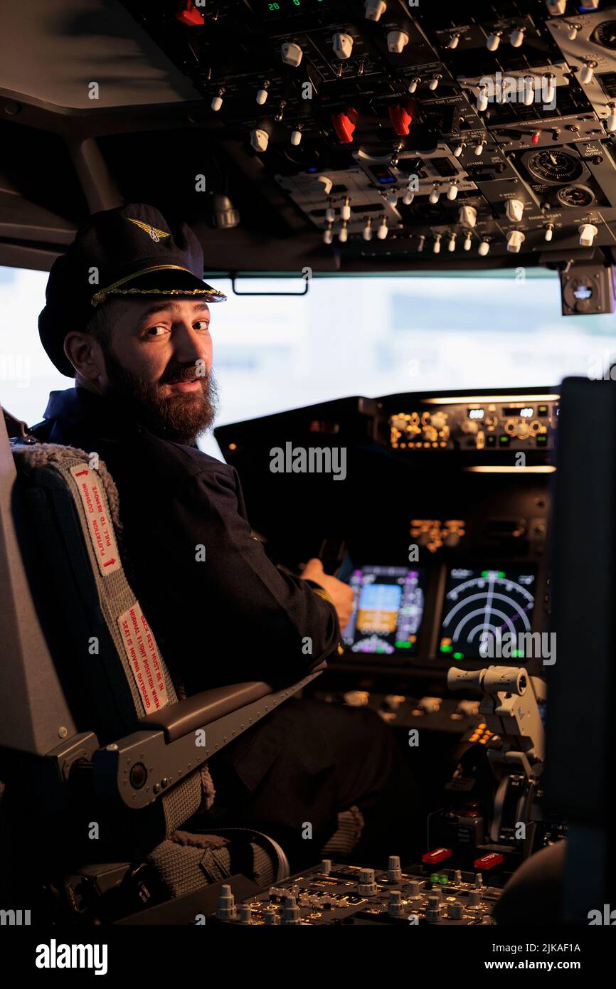 Portrait of caucasian captain using cockpit dashboard command to ...