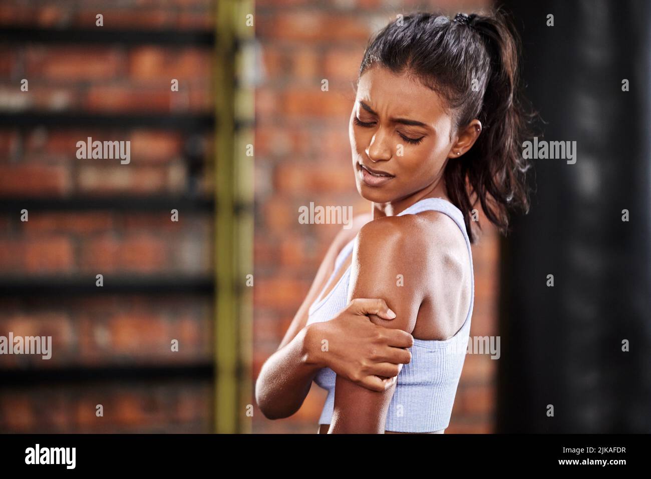 Sore muscles holding you back. a young woman suffering from an injury ...