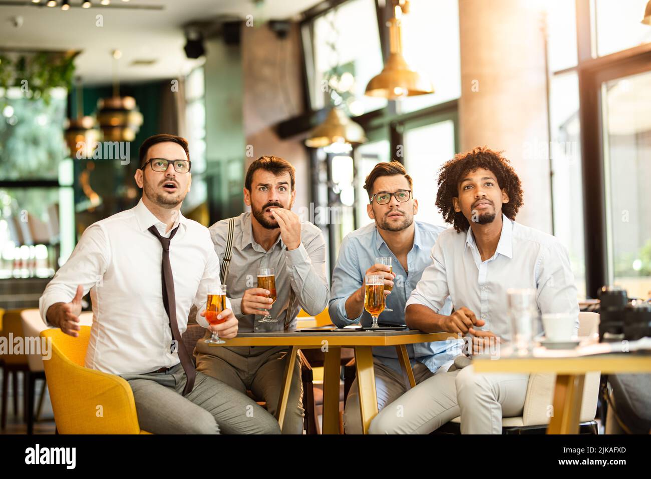 Cheerful fans watching TV and delight football. Four successful men ...