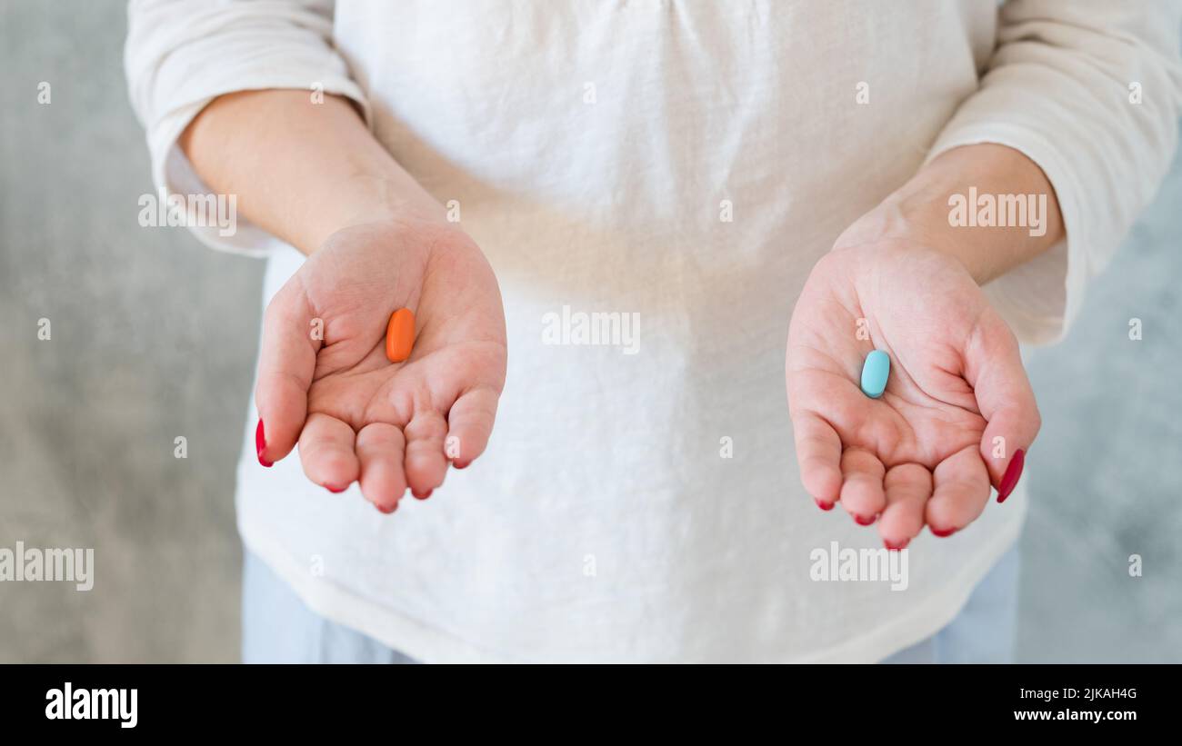 dilemma choice woman hold red blue capsule Stock Photo - Alamy
